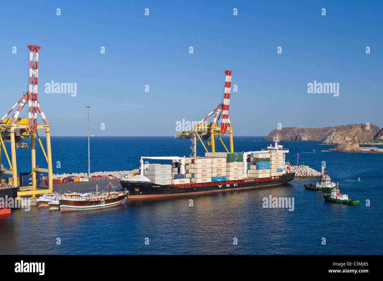 A container ship being loaded at the port city of Muscat Oman Stock ...