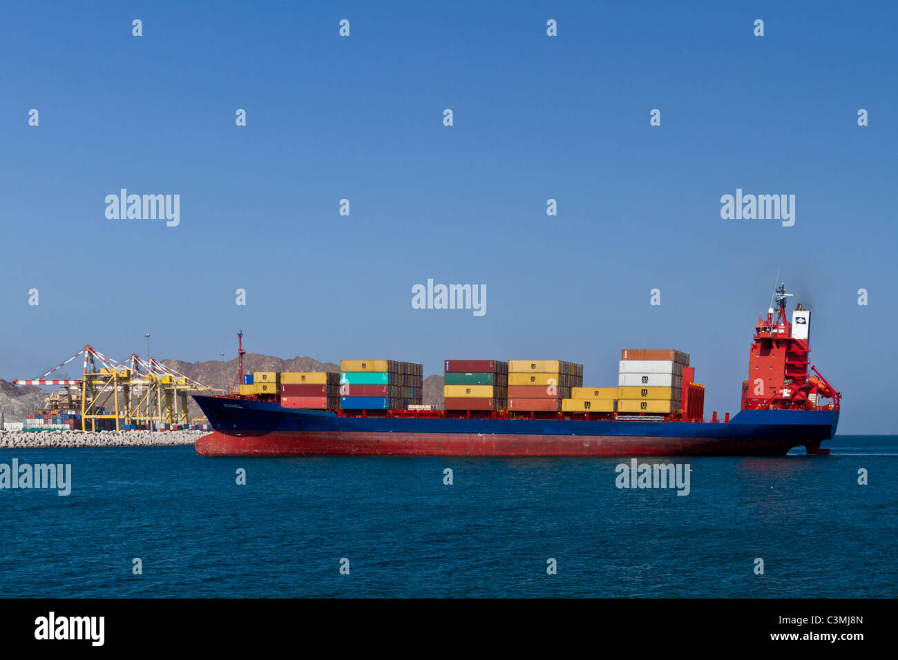 A container ship entering Port Sultan Qaboos in Muscat, Oman Stock ...