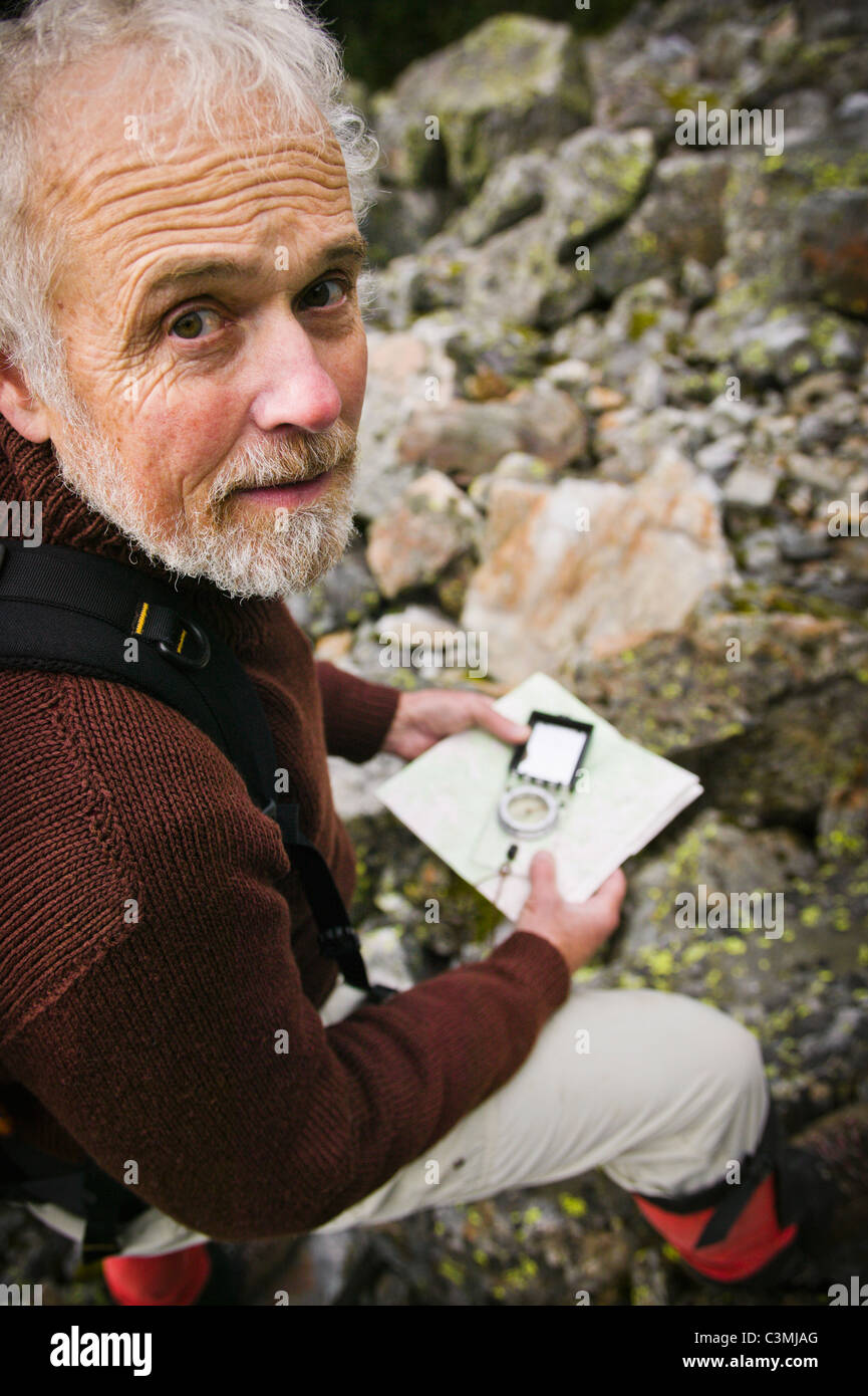 A portrait of a man using a map and compass Stock Photo - Alamy