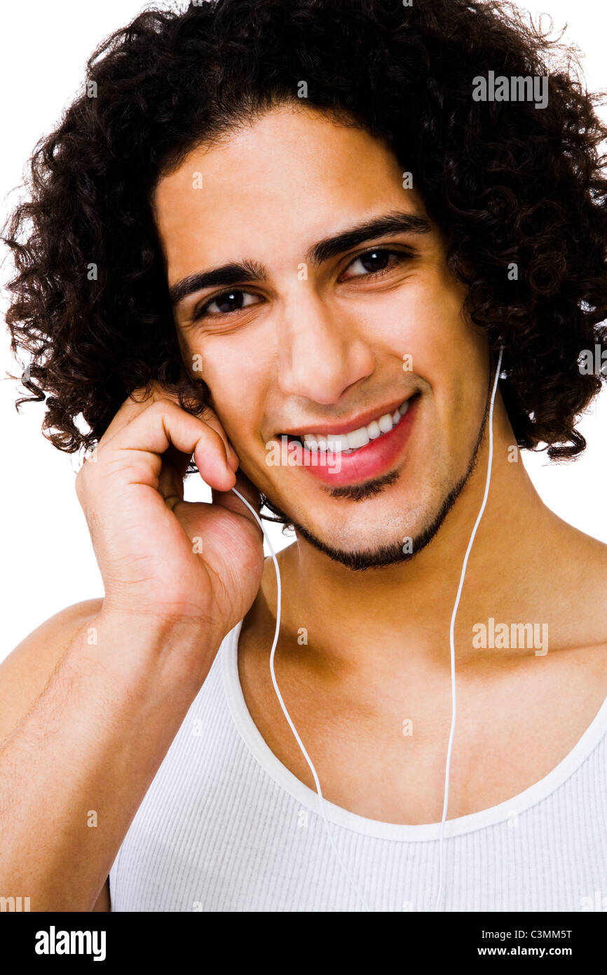 Handsome man listening to music on a MP3 player isolated over white ...