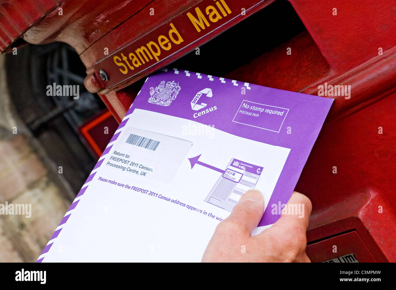 Close up of man person posting completed 2011 census survey form forms ...