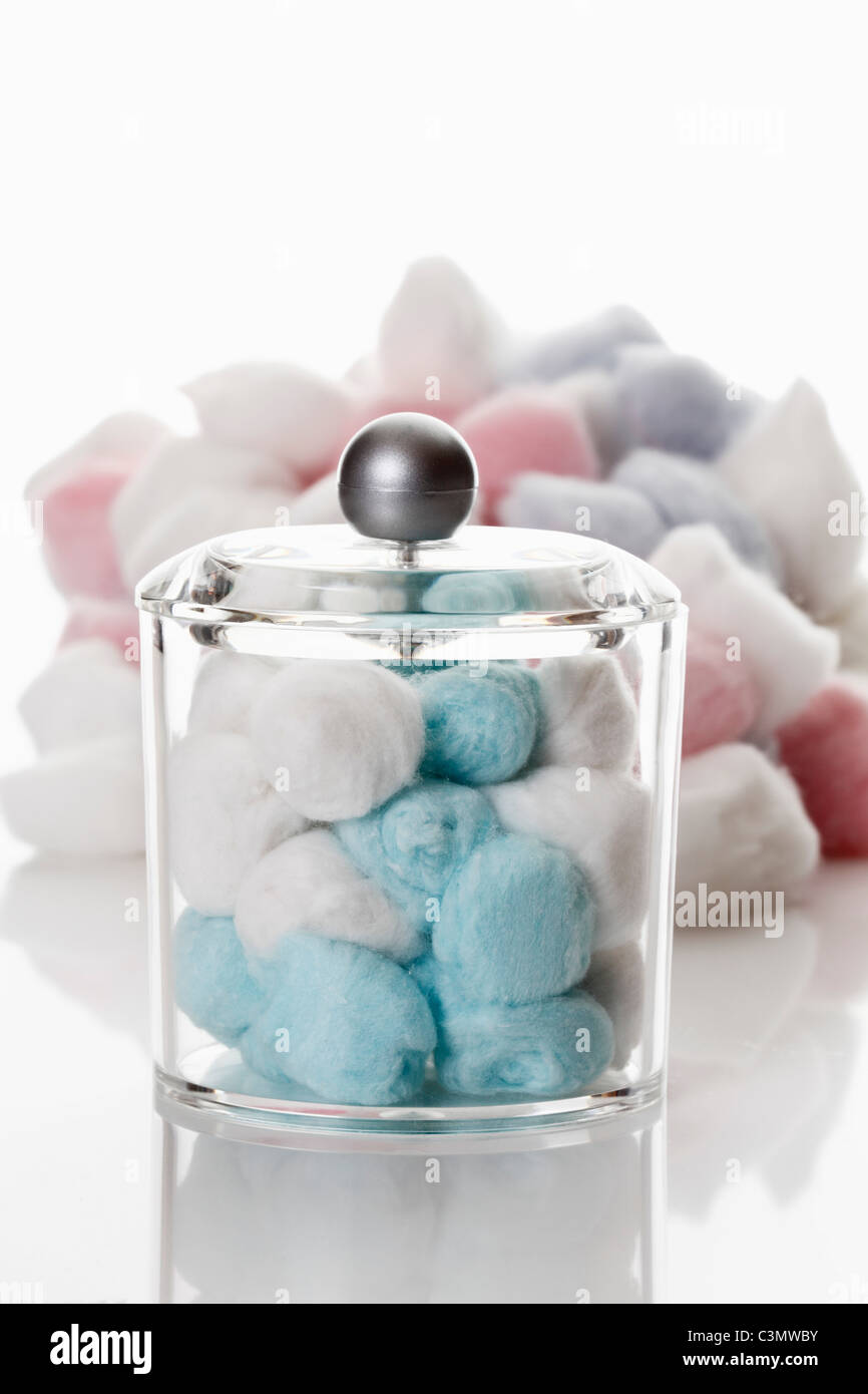 Cotton balls in container on white background Stock Photo - Alamy