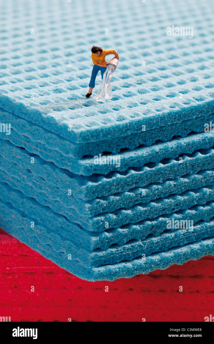 Woman figurine pouring water on sponge cloth Stock Photo - Alamy