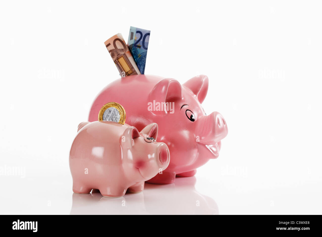 Piggy bank with euro notes and coin on white background Stock Photo - Alamy
