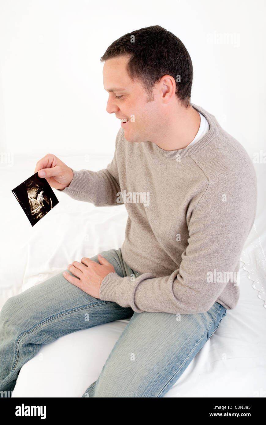 Dad to be looking at ultrasound scan of his baby Stock Photo - Alamy