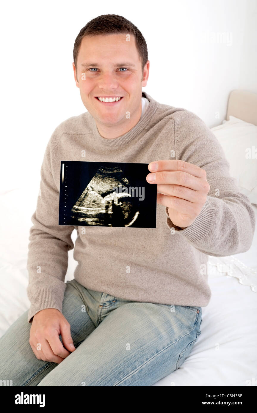 Excited dad to be holding ultrasound scan Stock Photo - Alamy