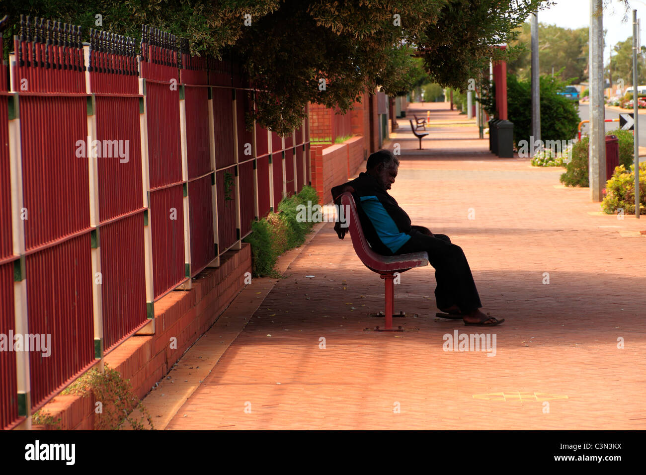 Old Aboriginal man sitting on a bench seat, Leonora Western Australia ...