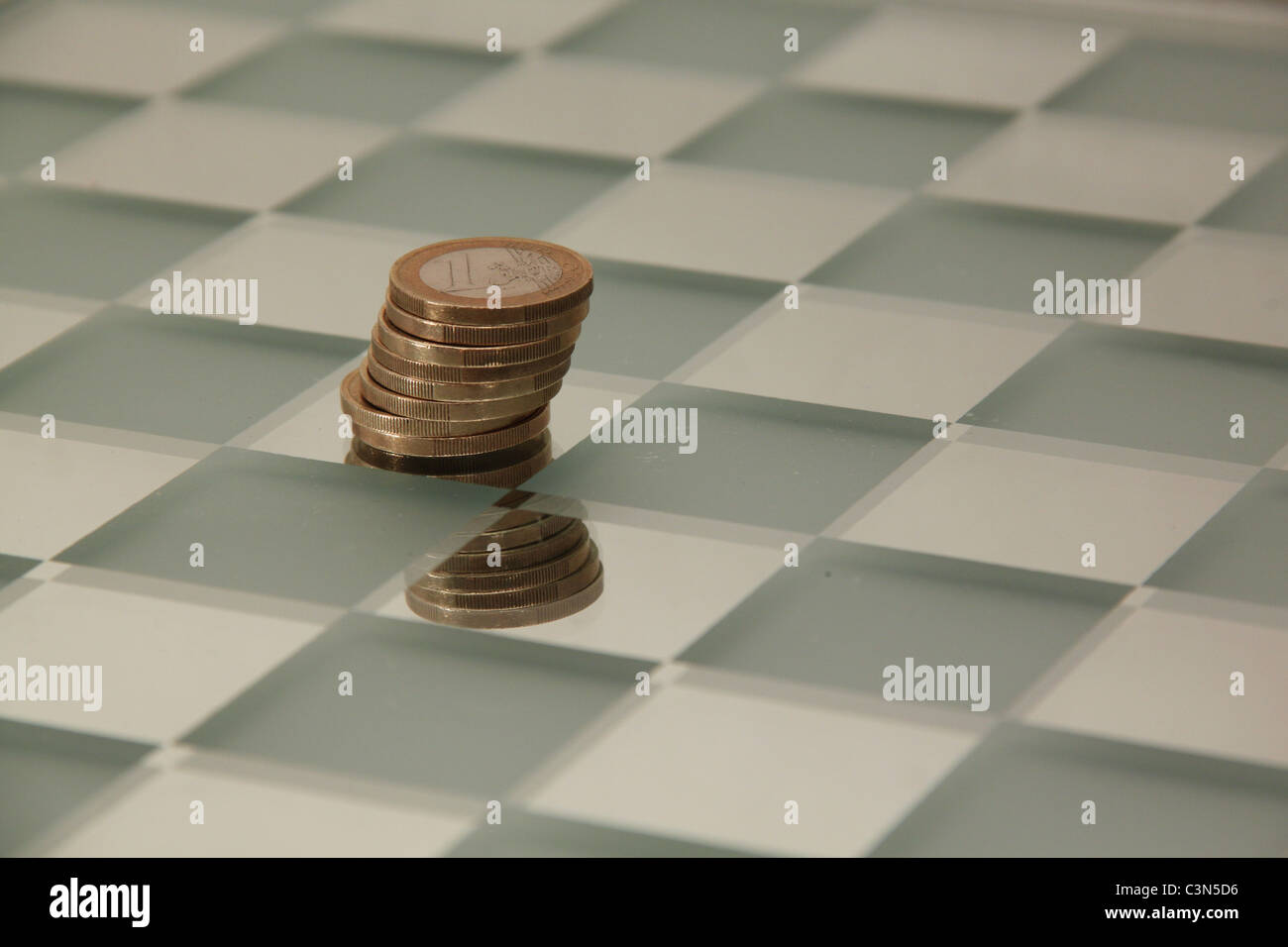 tower of euro coins on a chessboard Stock Photo - Alamy