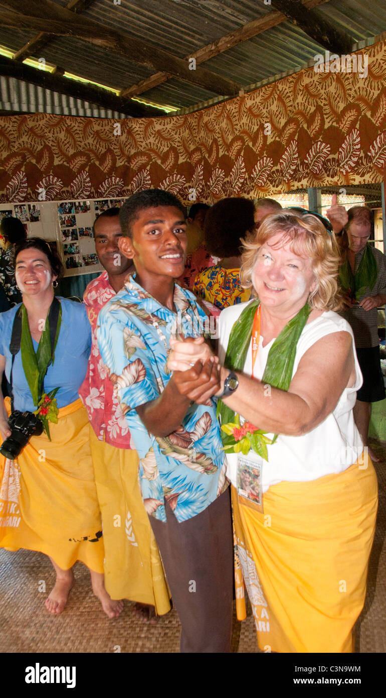Tourists dancing with local fijians in native kava cermony Naveyago ...