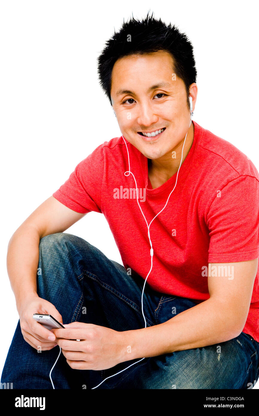 Smiling man listening to music on a MP3 player isolated over white ...