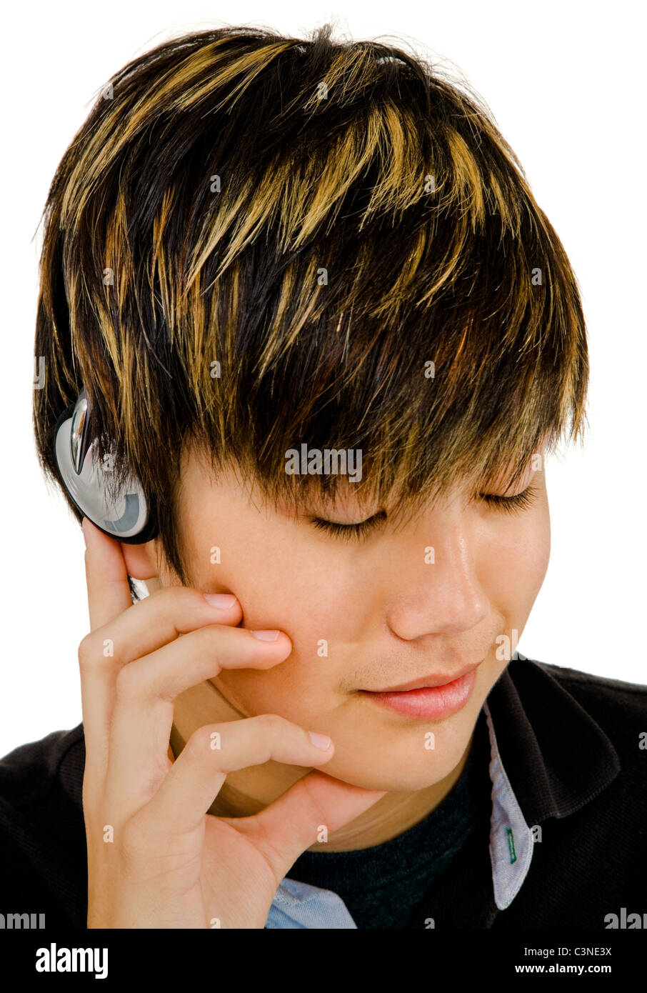 Close-up of a teenage boy talking on a bluetooth and posing isolated ...