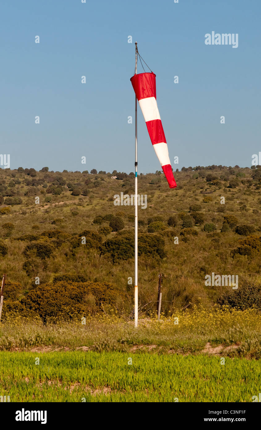 An airport windsock in a wheat field on a sunny early morning showing a ...