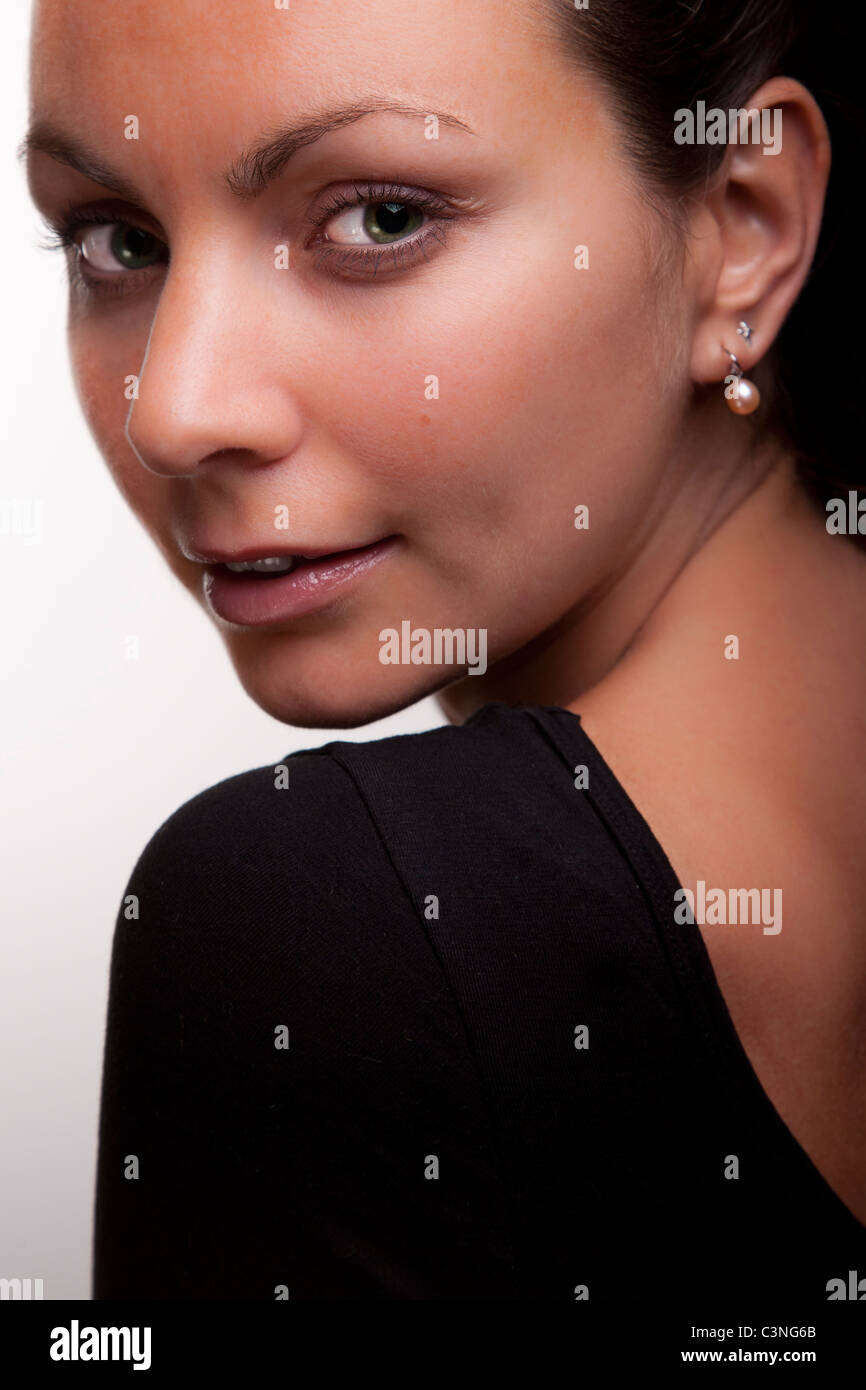 Portrait of a young woman looking over her shoulder Stock Photo - Alamy