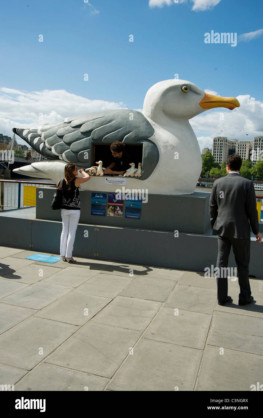 man watches woman talking to man in giant seagull on London's Southbank ...