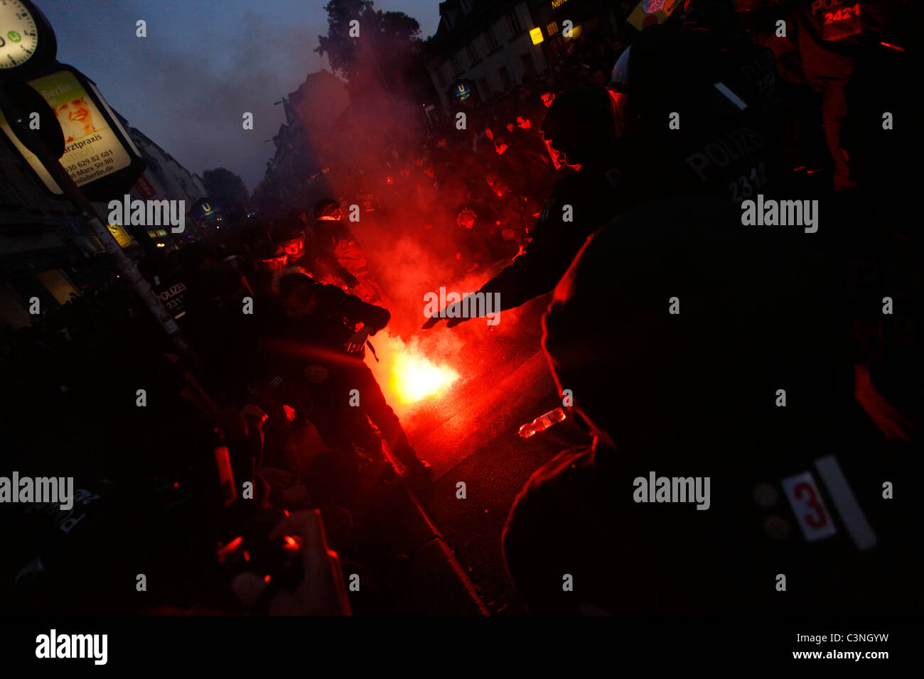 Demonstrators and policemen stand around red flare as violent clashes ...