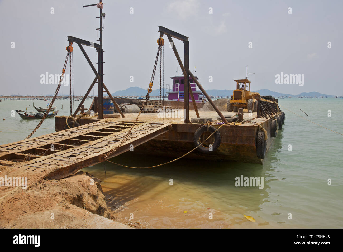 A barge carrying building materials being unloaded in Chalong bay ...