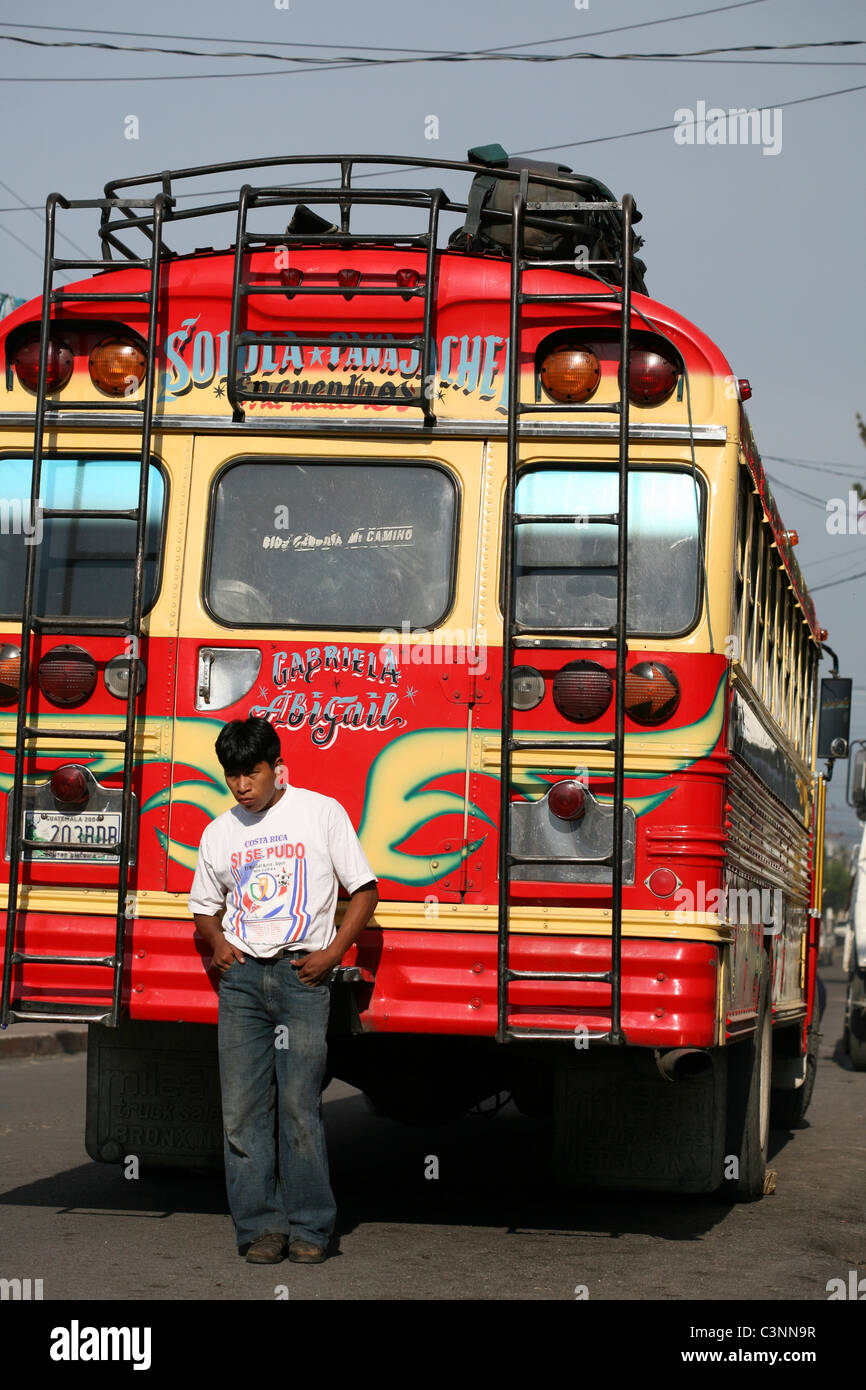 A fare collector waits for passengers for his colorful chicken bus ...
