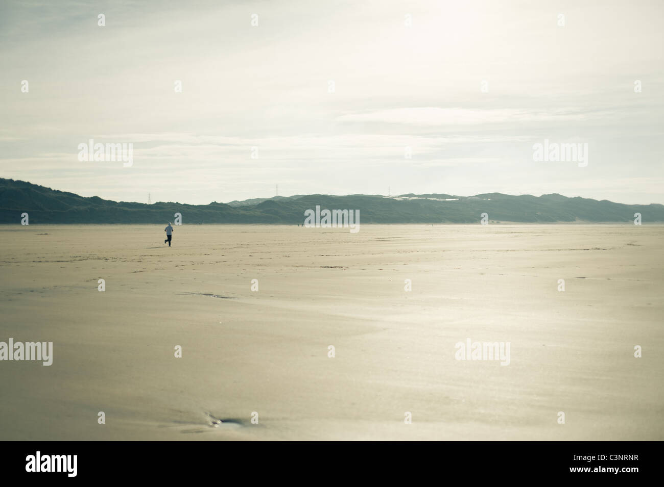 A man running across the empty beach at Hayle, Cornwall Stock Photo - Alamy