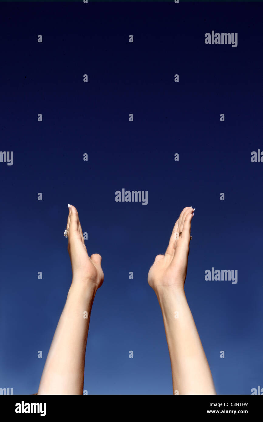 Womans hands reaching up to a blue sky waiting to catch something Stock ...
