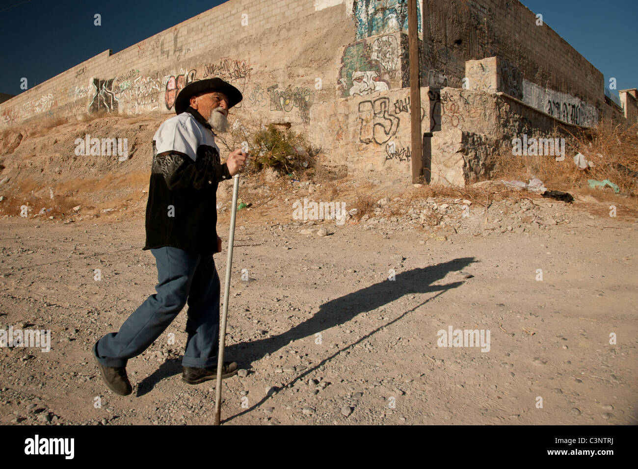 An elderly man walks past gang markers in memory of a slain drug ...