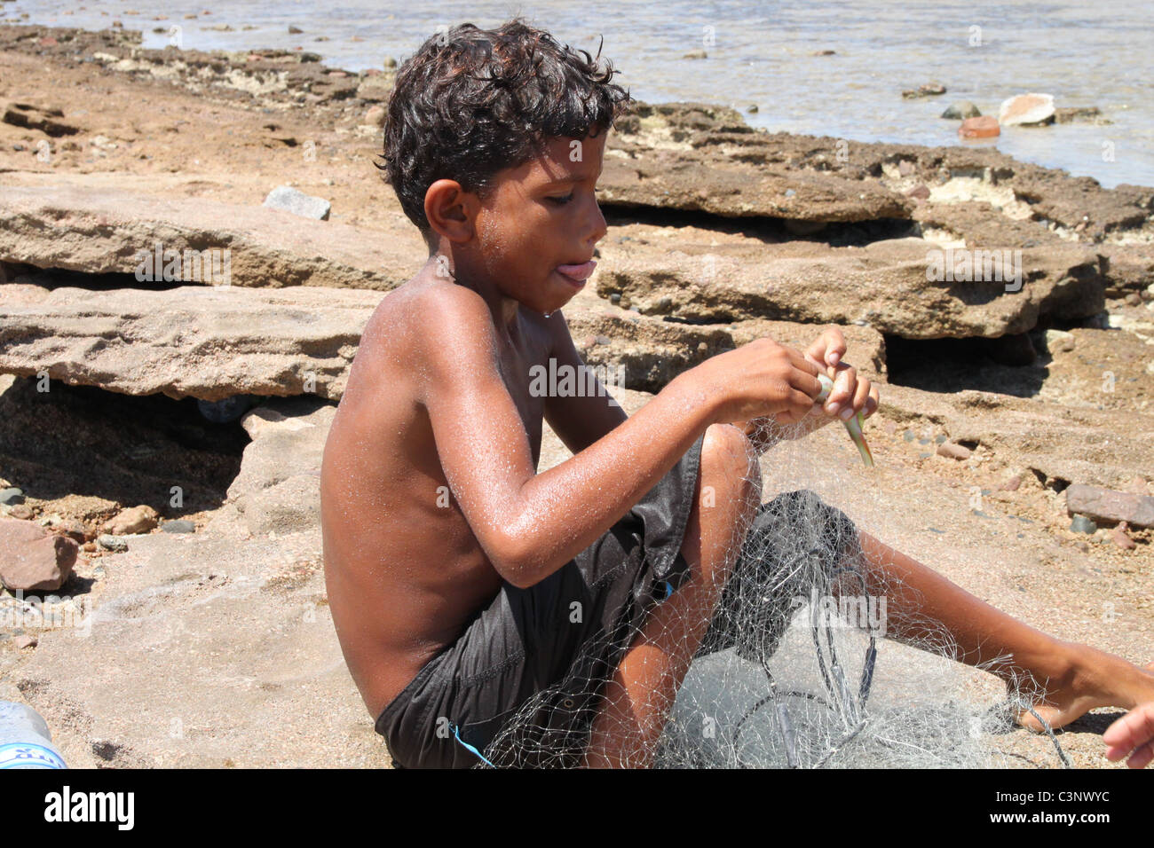 A Bedouin Boy Fishing On The Shore By The Red Sea In Dahab Egypt Stock