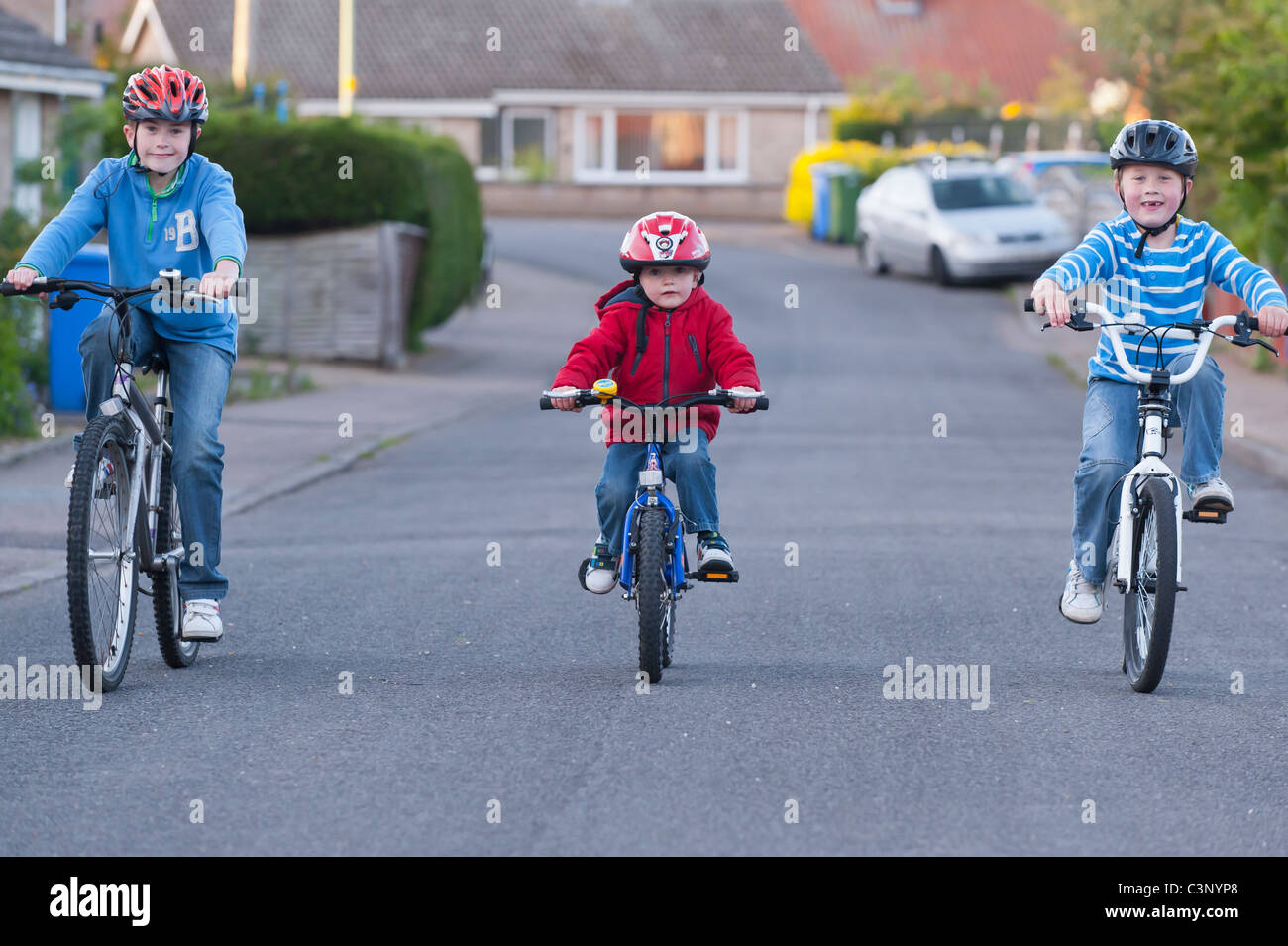 Kids riding bikes on street happy hi-res stock photography and images ...
