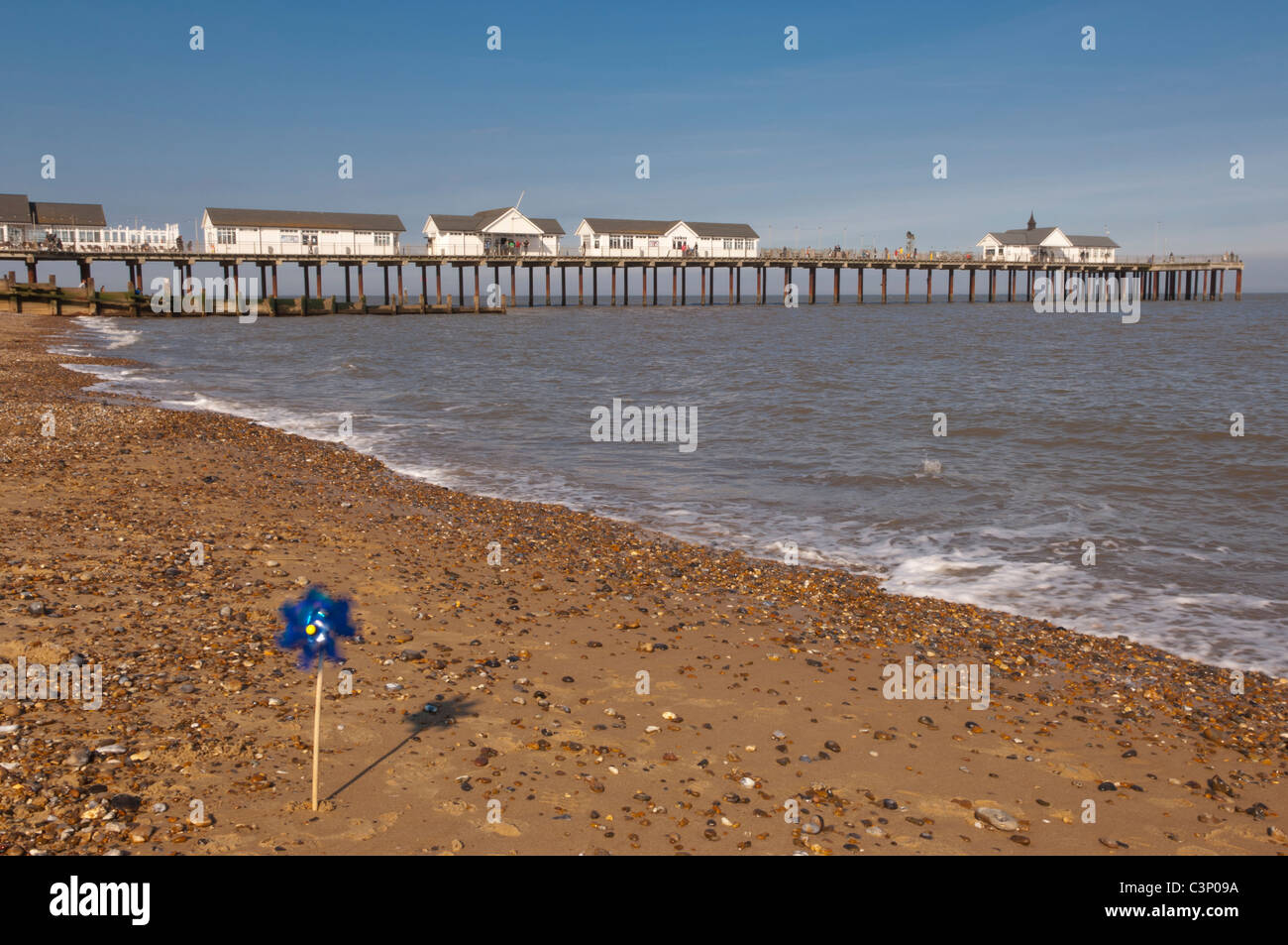A childs toy windmill on the beach near the pier at Southwold , Suffolk ...
