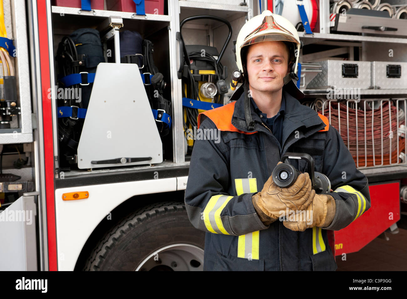 Picture from a young and successful firefighter at work Stock Photo - Alamy
