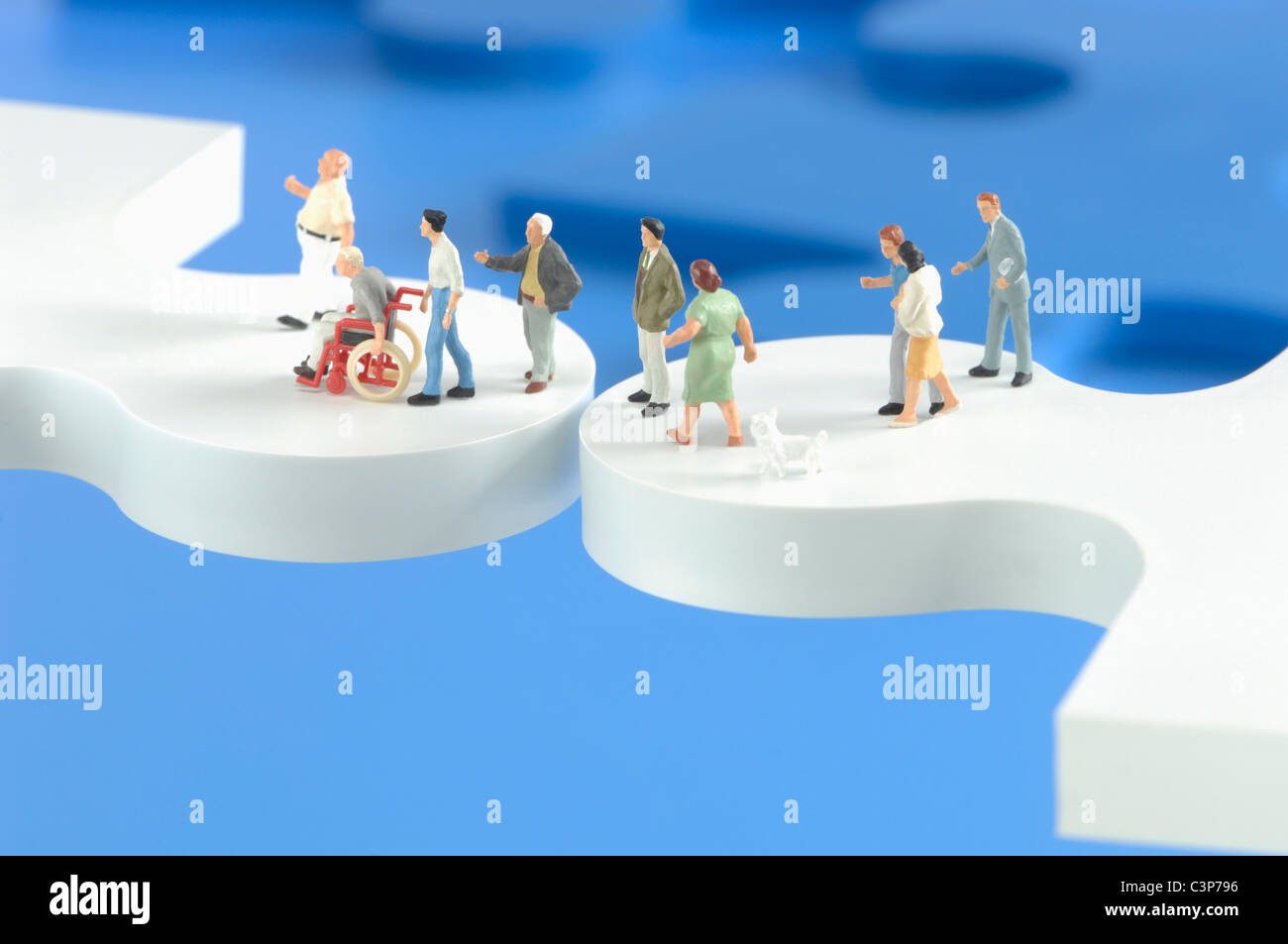 Plastic figurines on puzzle pieces Stock Photo - Alamy