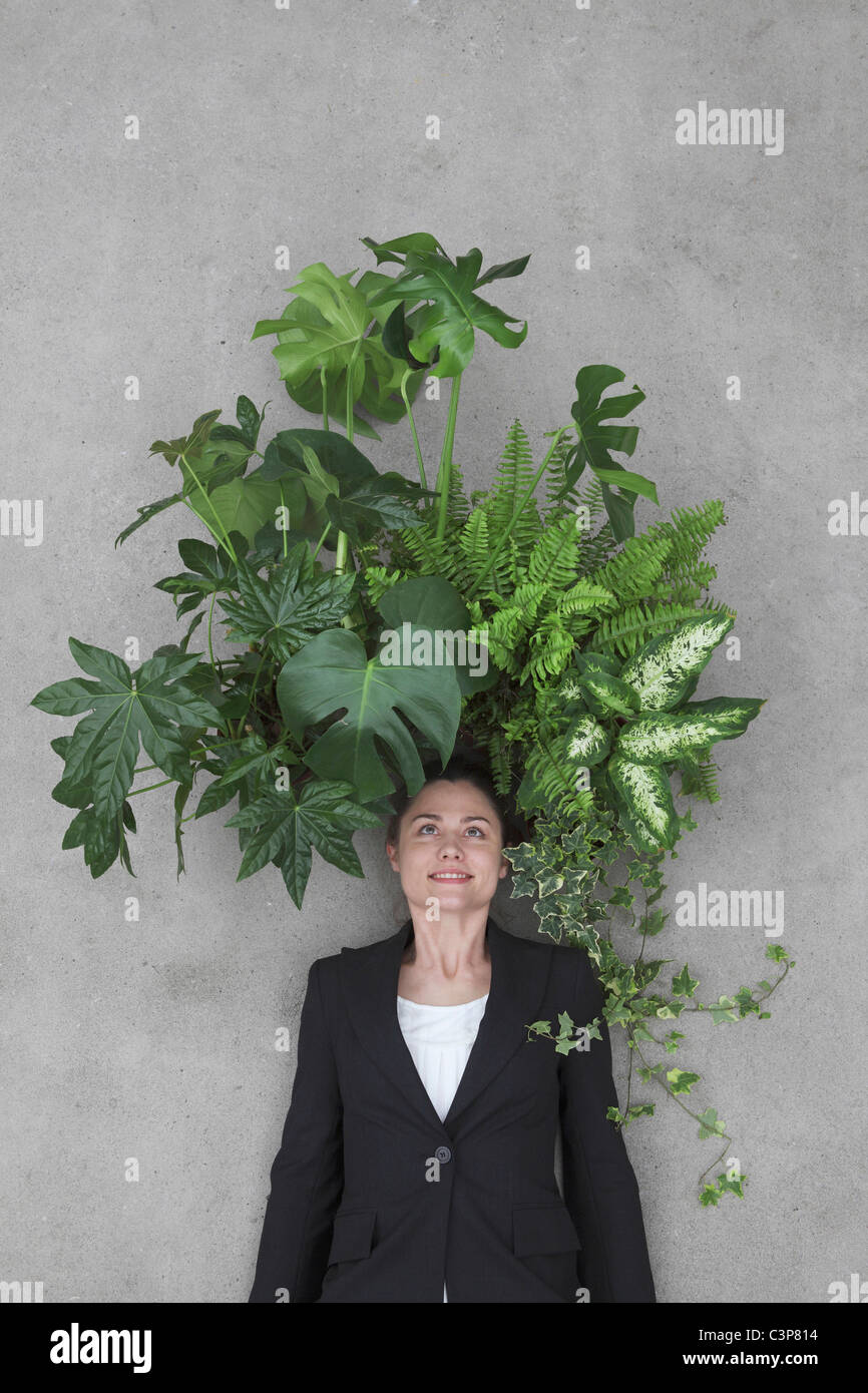 Businesswoman with foliage plants on head, smiling, portrait, elevated ...