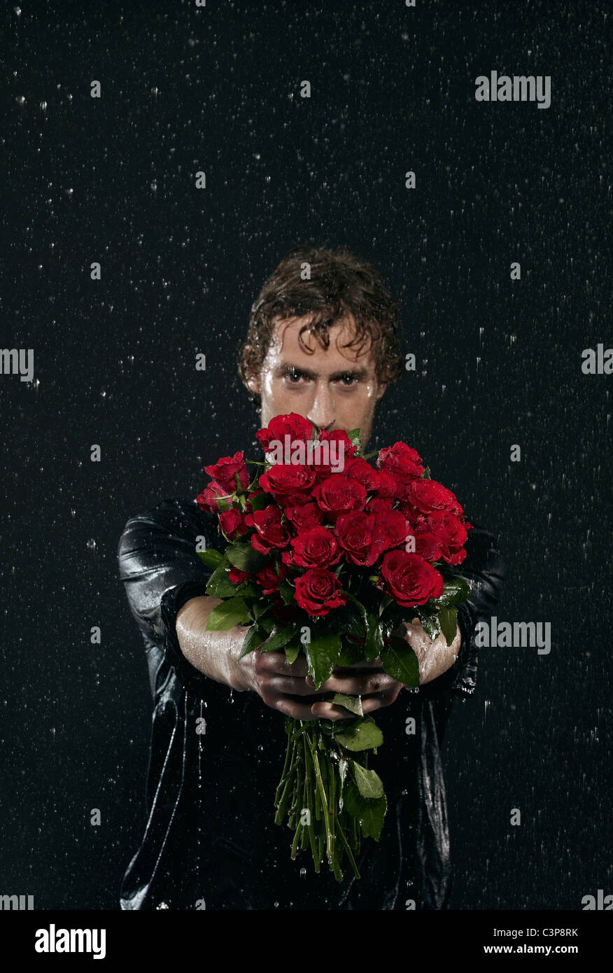 Man holding bunch of flowers, standing in rain Stock Photo - Alamy
