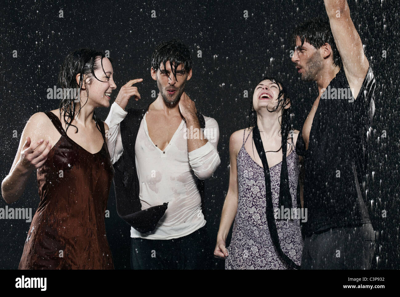 Friends enjoying in rain, smiling Stock Photo - Alamy