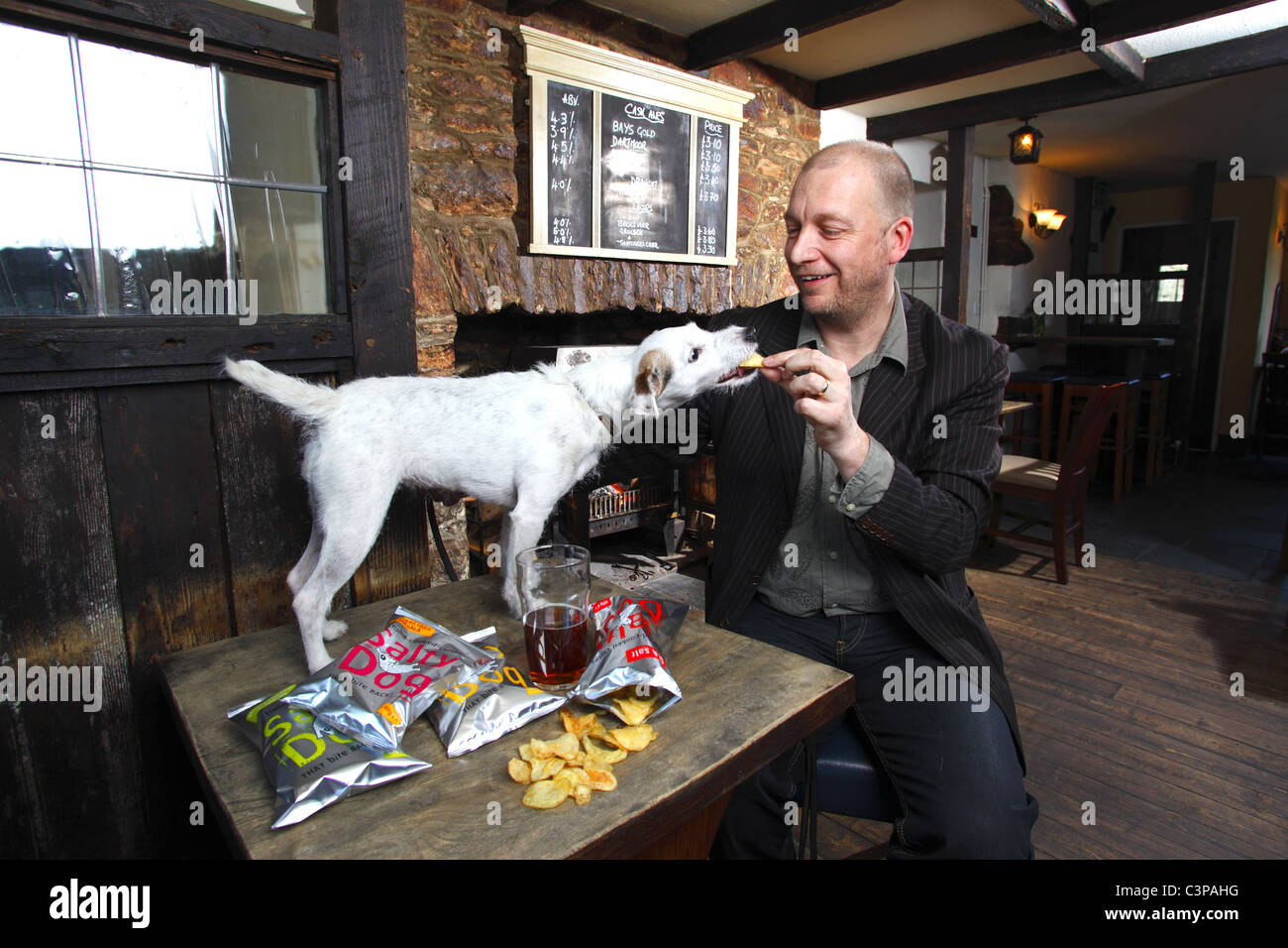 Man in pub with dog, a pint and crisps Stock Photo - Alamy