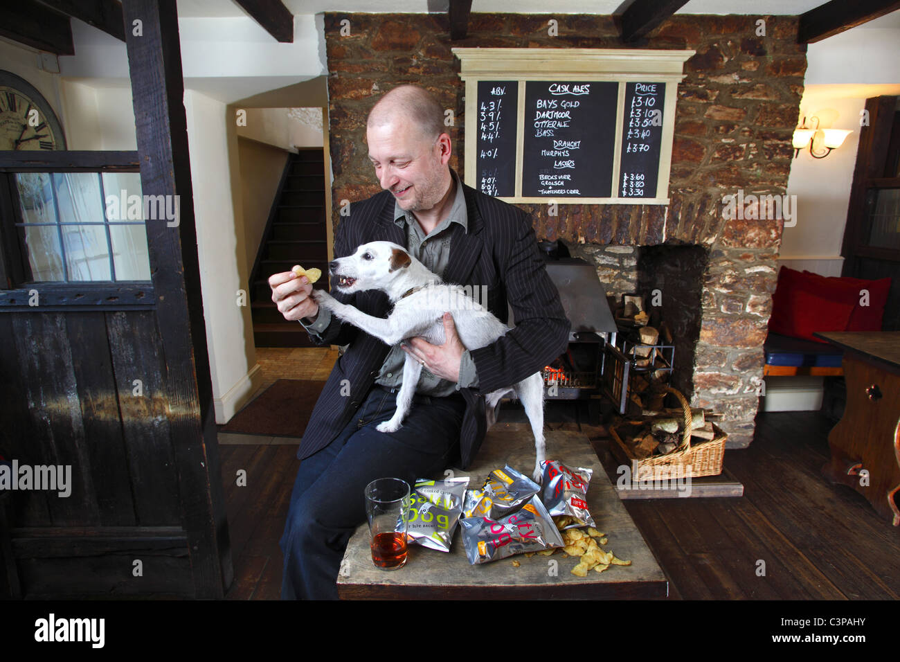 Man in pub with dog, a pint and crisps Stock Photo - Alamy