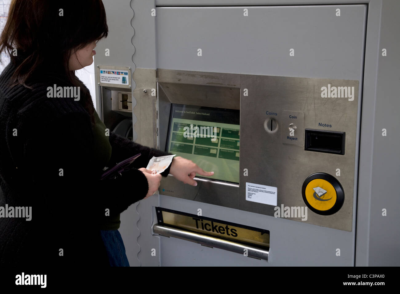 teenage girl using ticket machine at railway station cheam surrey ...