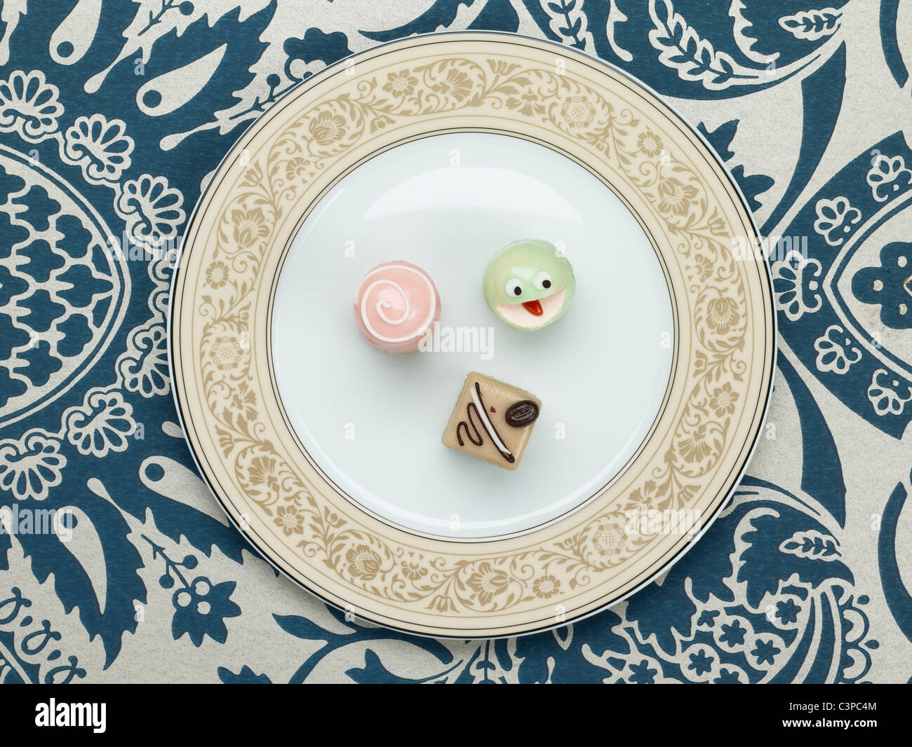 Petit fours in plate against patterned background Stock Photo - Alamy