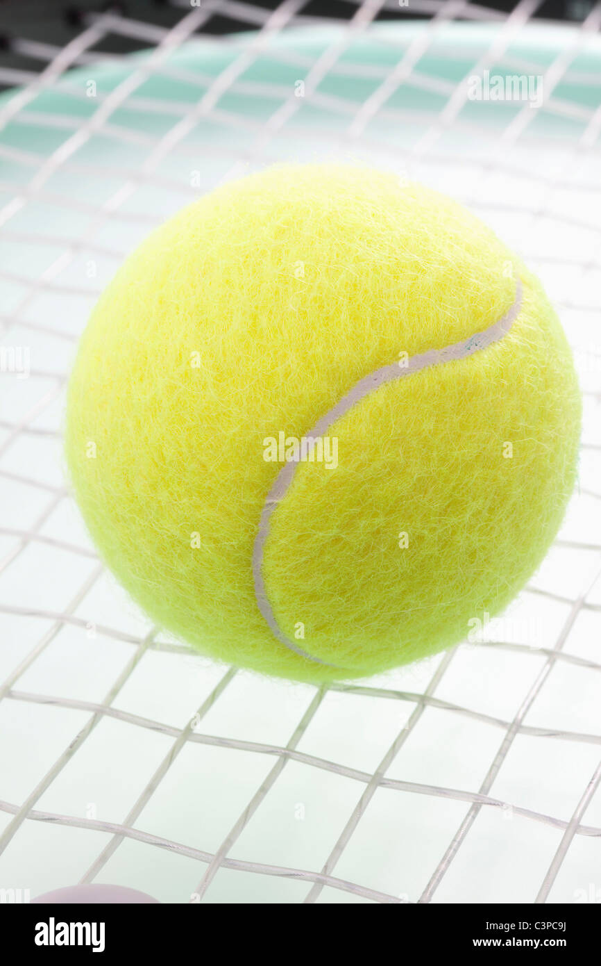 Tennis ball on racket, close-up Stock Photo - Alamy