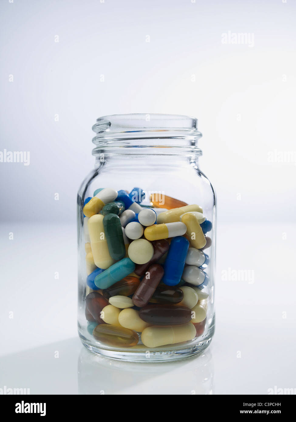 Glass jar full of pills on white background Stock Photo - Alamy