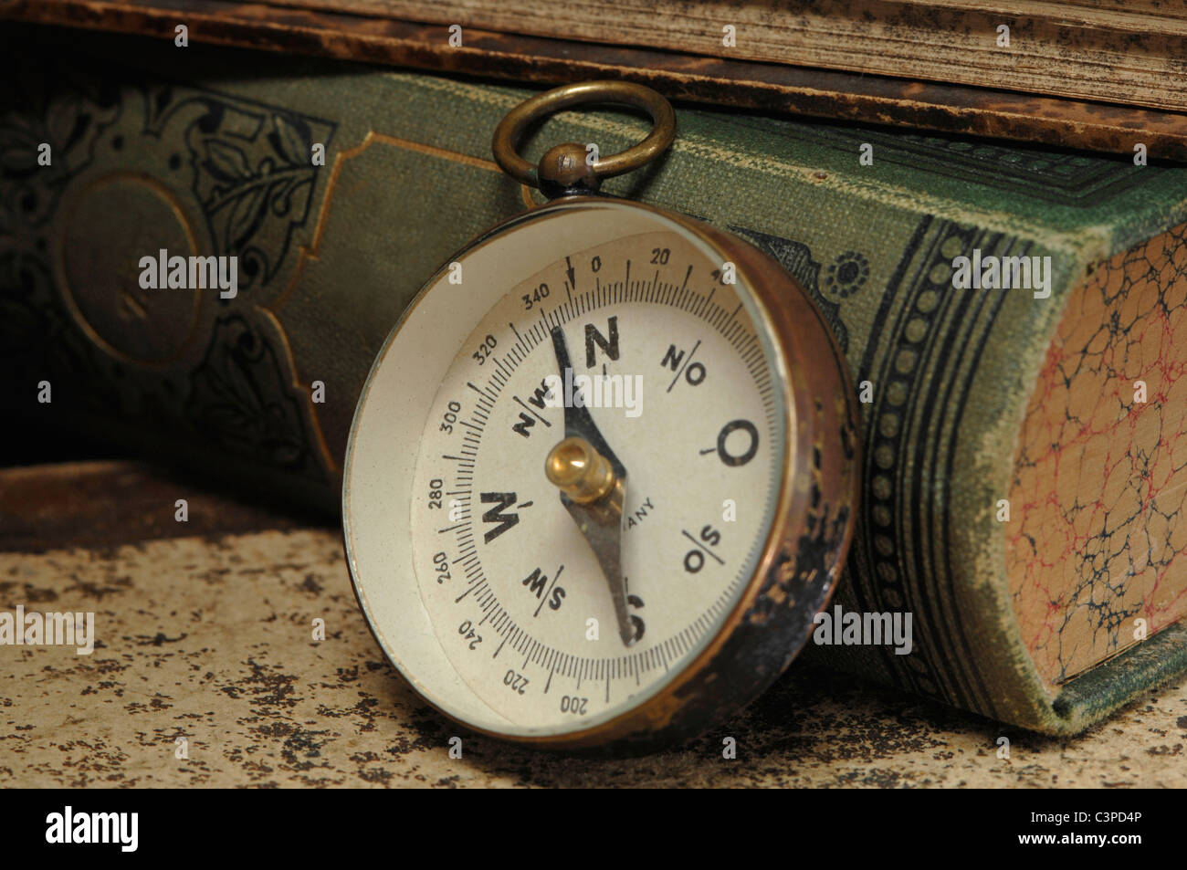Compass with old book, close up Stock Photo - Alamy