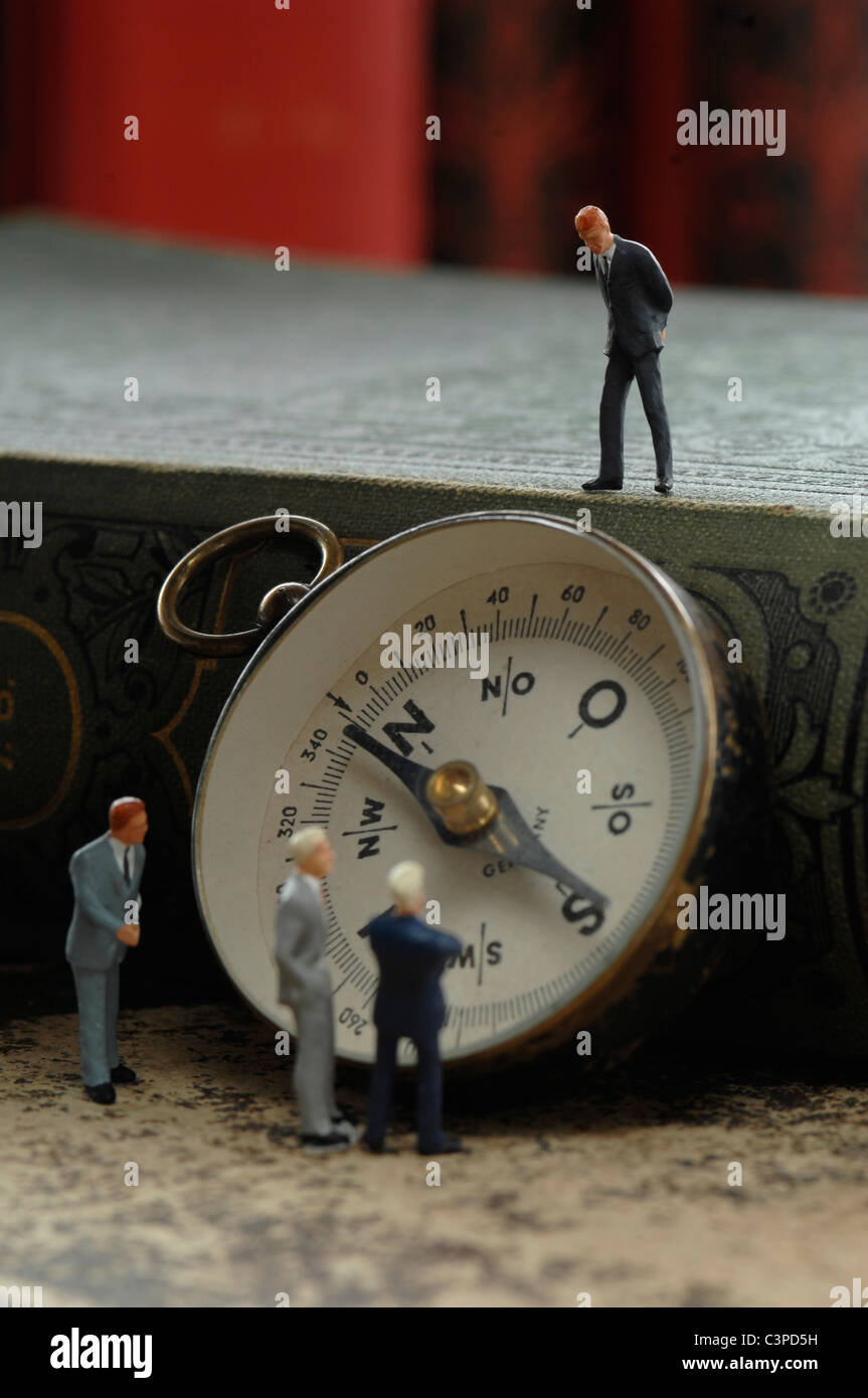 Compass with figurine and book hi-res stock photography and images - Alamy