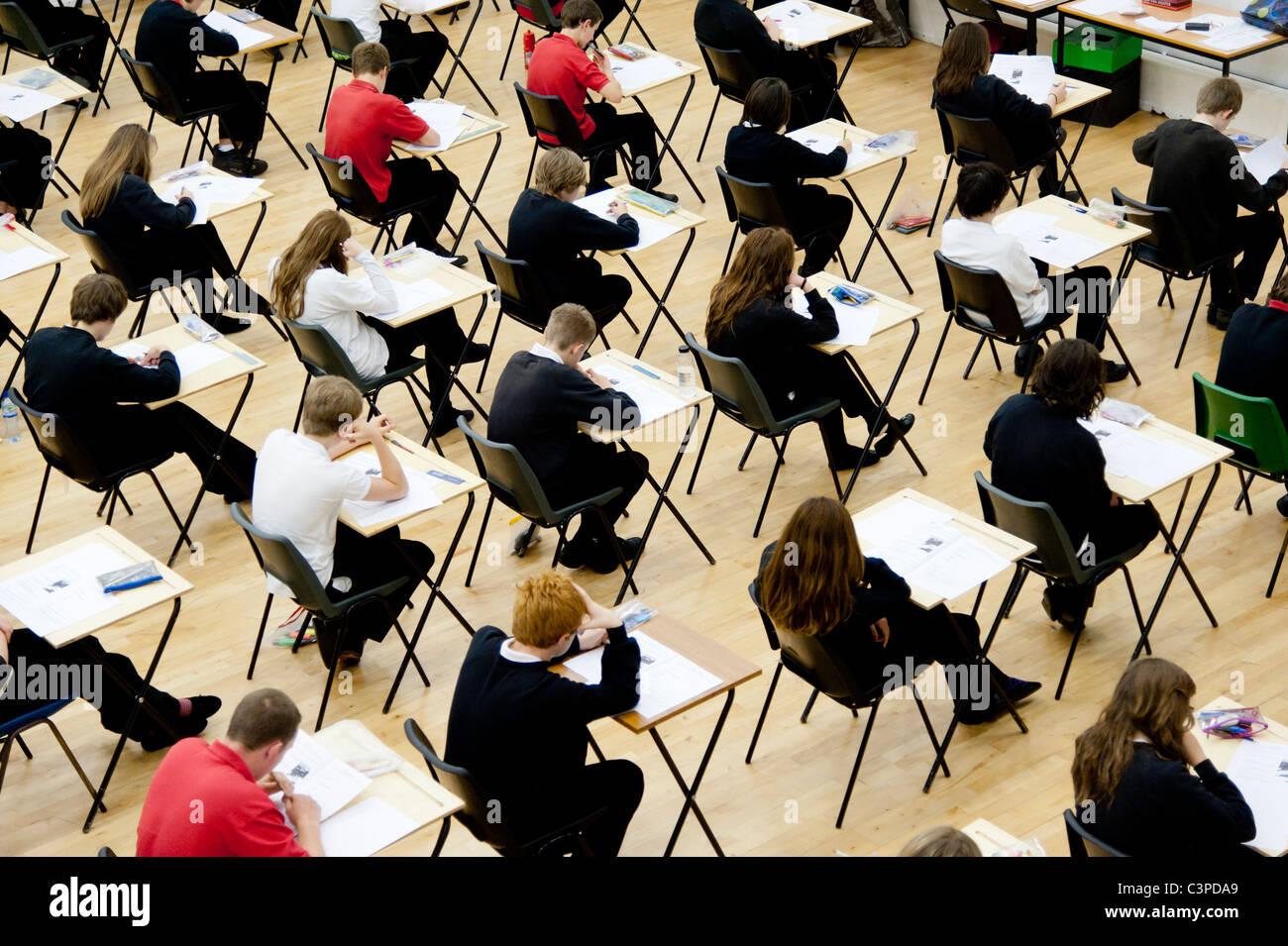 Rows of teenage boy and girl school students sitting their GCSE ...