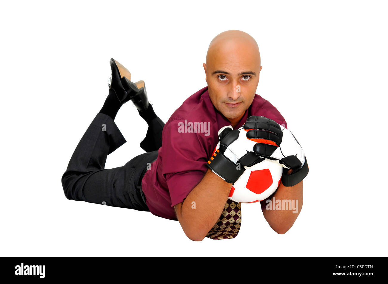 Businessman goalkeeper with gloves and ball in a acrobatic save ...