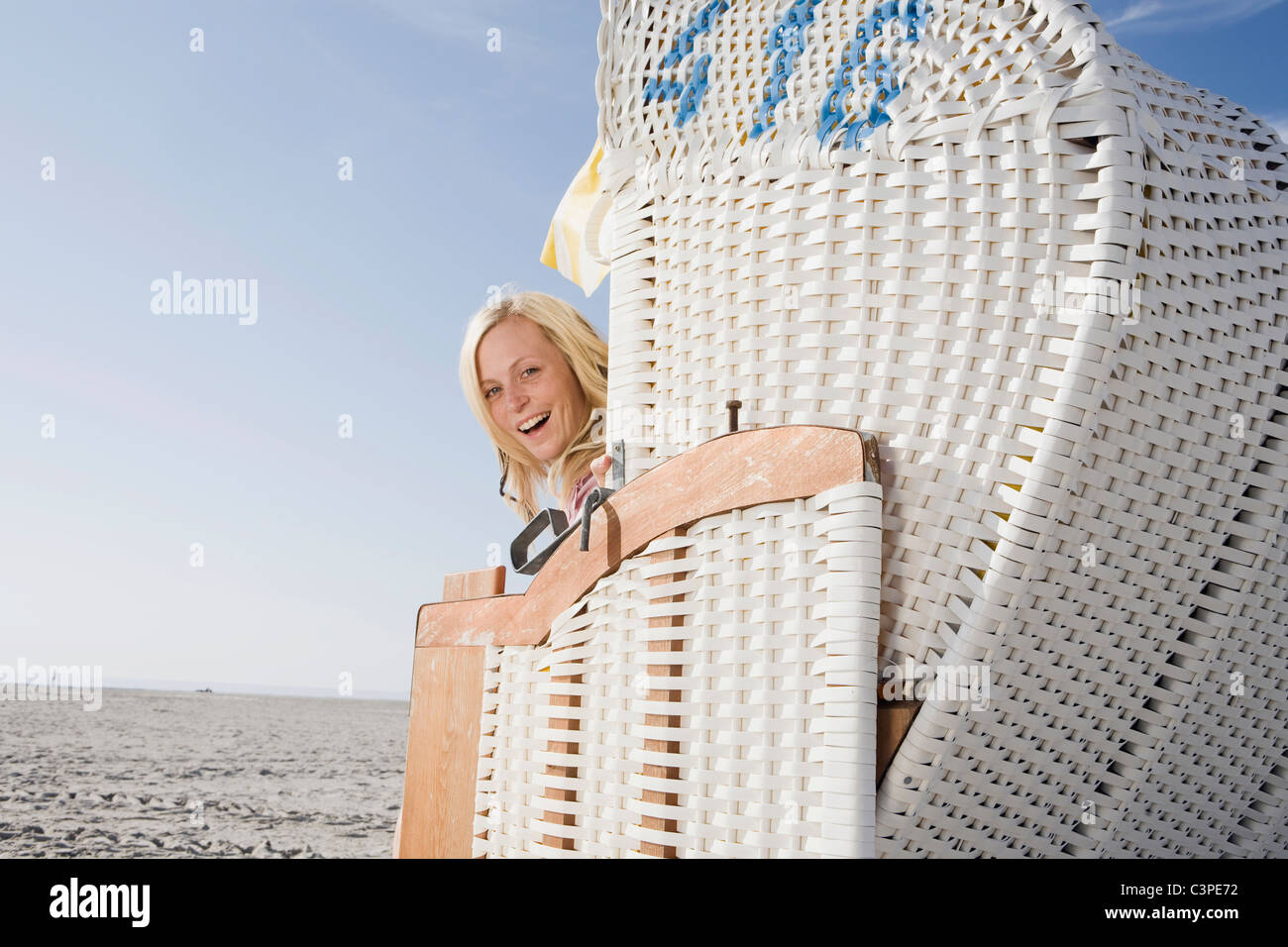 Germany, Schleswig Holstein, Amrum, Woman sitting in beach chair ...