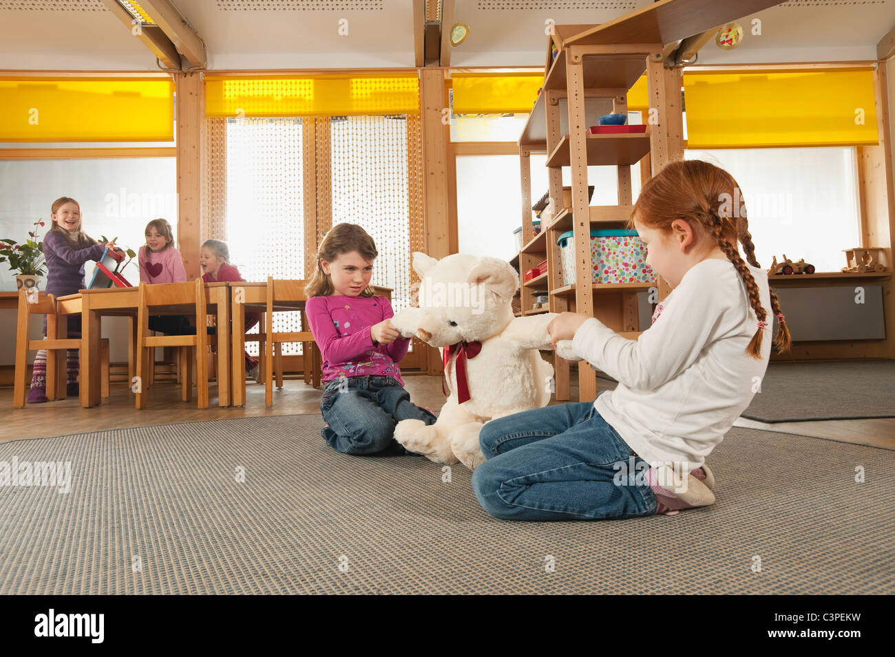 Germany, Children in nursery, Two girls (4-5), (6-7) fighting over ...