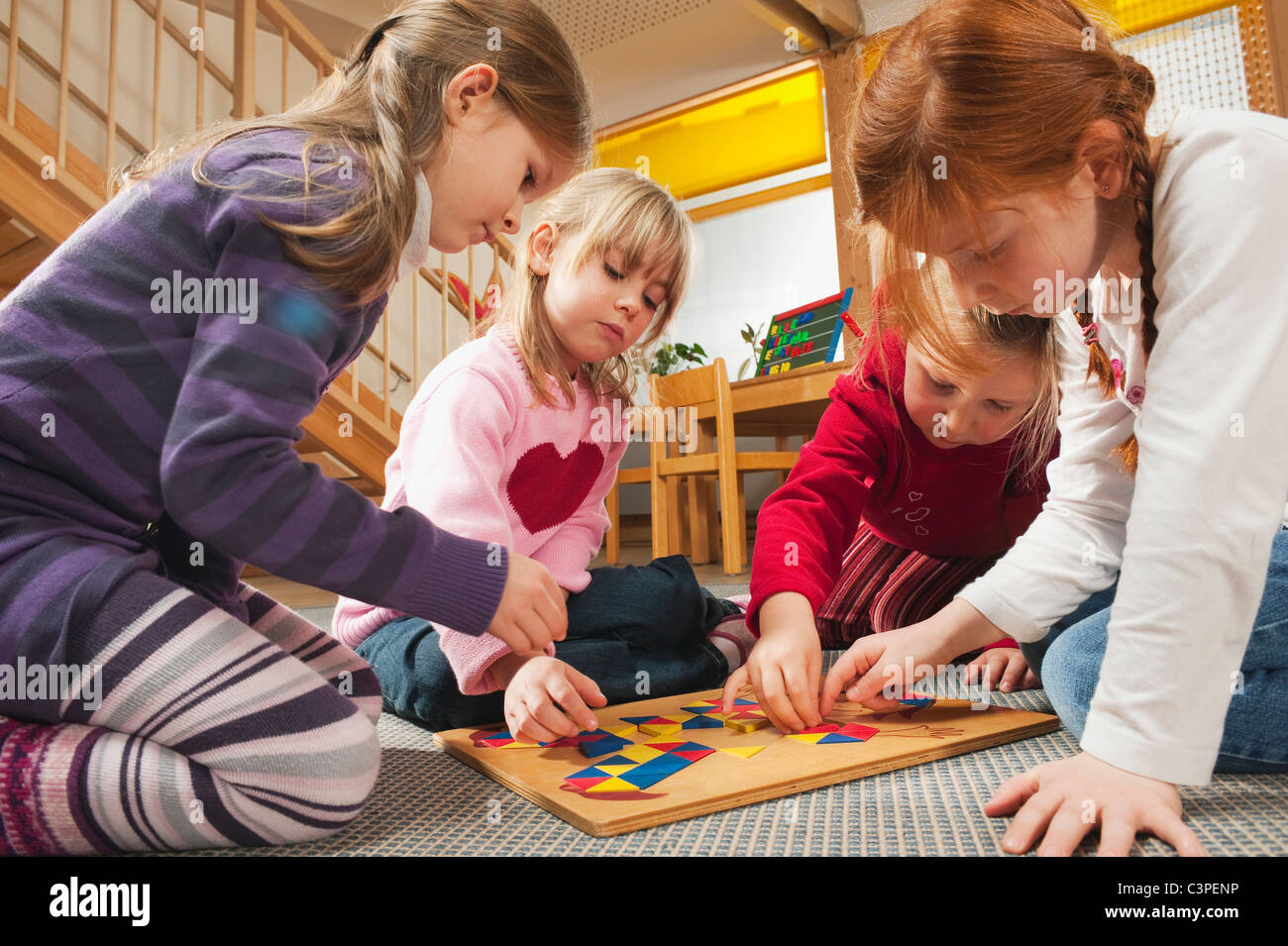 Germany, Children in nursery playing a learning game together, close-up ...