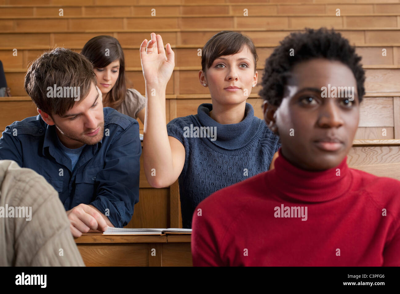 Germany, Leipzig, University students raising hand in classroom Stock ...