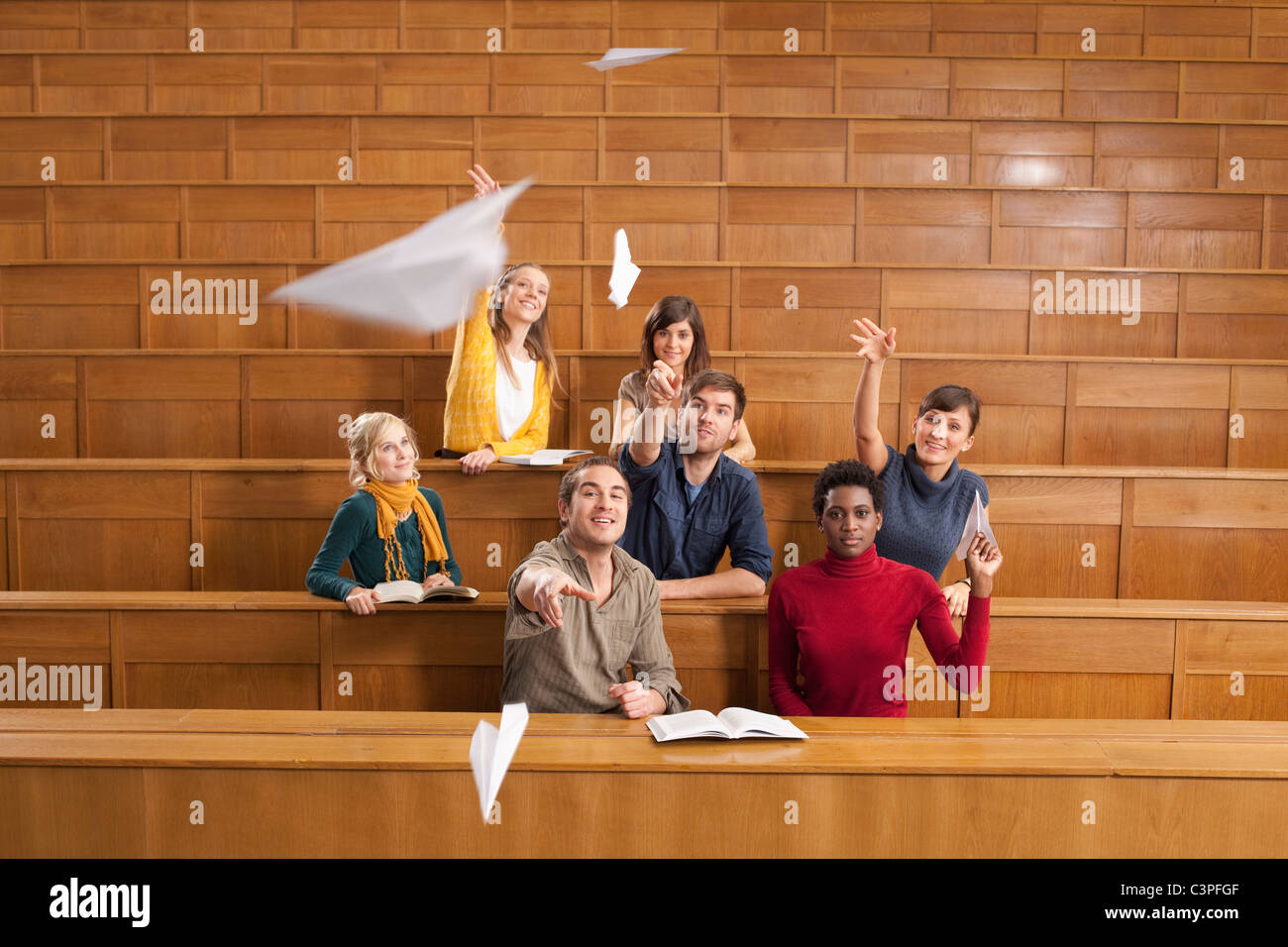 Germany, Leipzig, Group of university students throwing papers ...