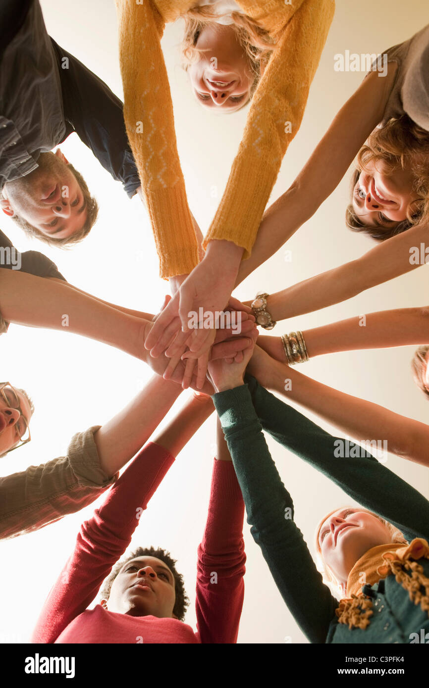 Germany, Leipzig, Group of university students putting hands together ...