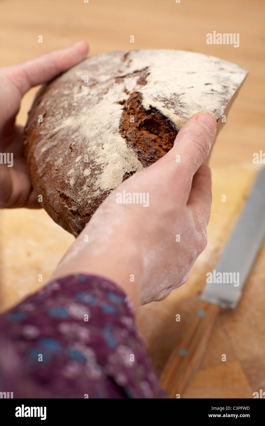 Person holding farmhouse bread, close-up Stock Photo - Alamy