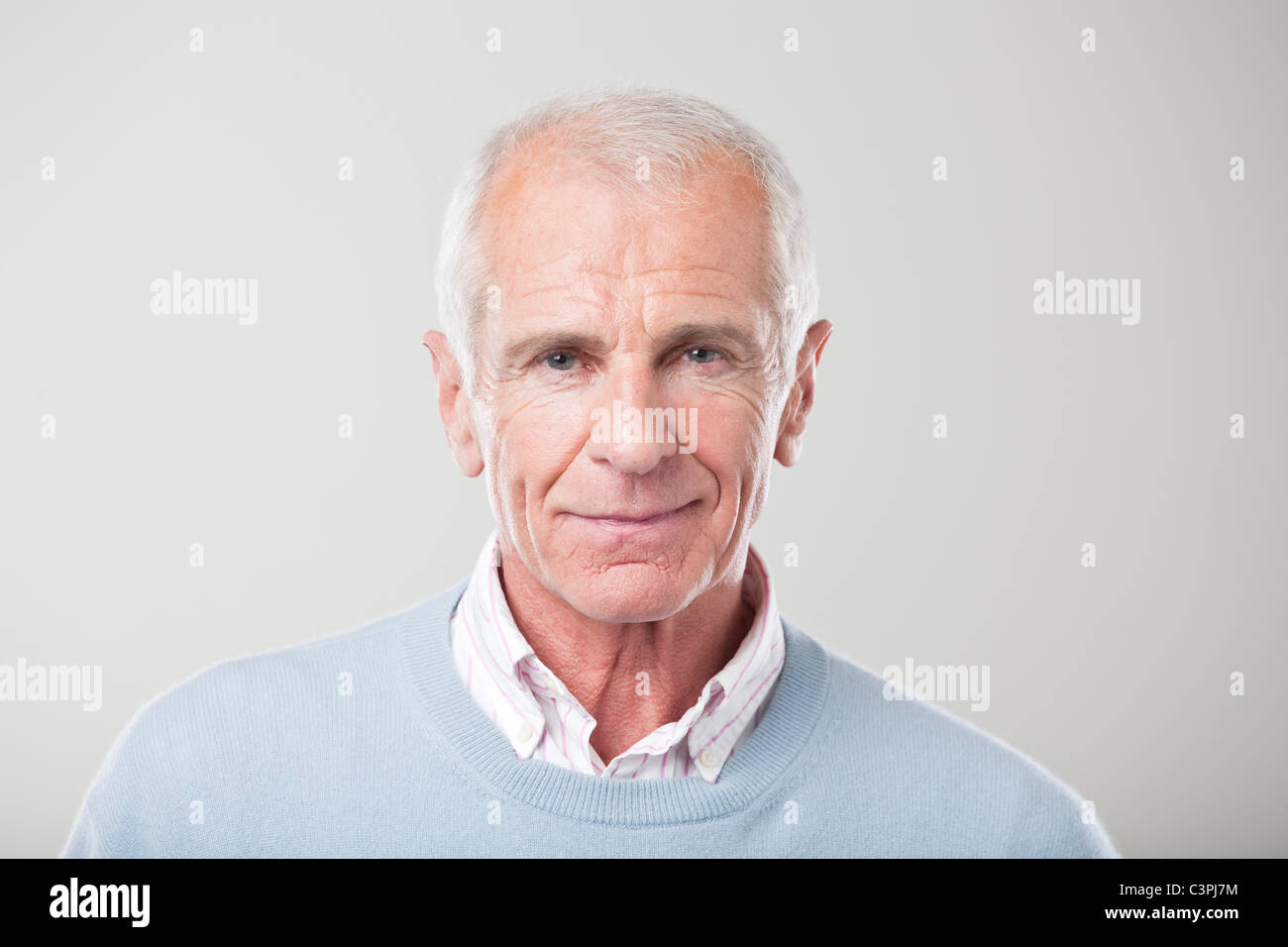 Man standing against gray background, smiling, portrait Stock Photo - Alamy